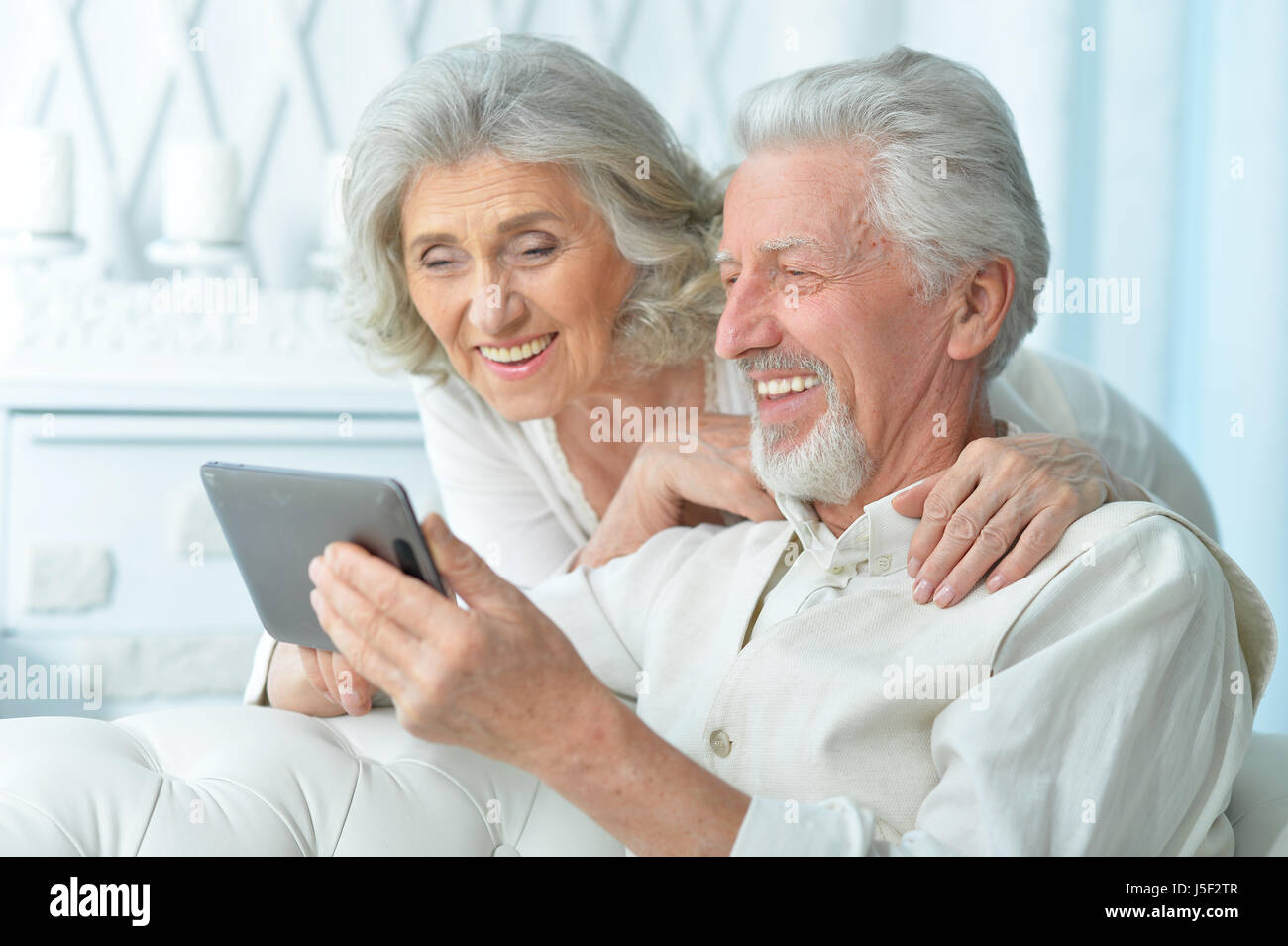 Happy elderly couple using a tablet computer Stock Photo - Alamy