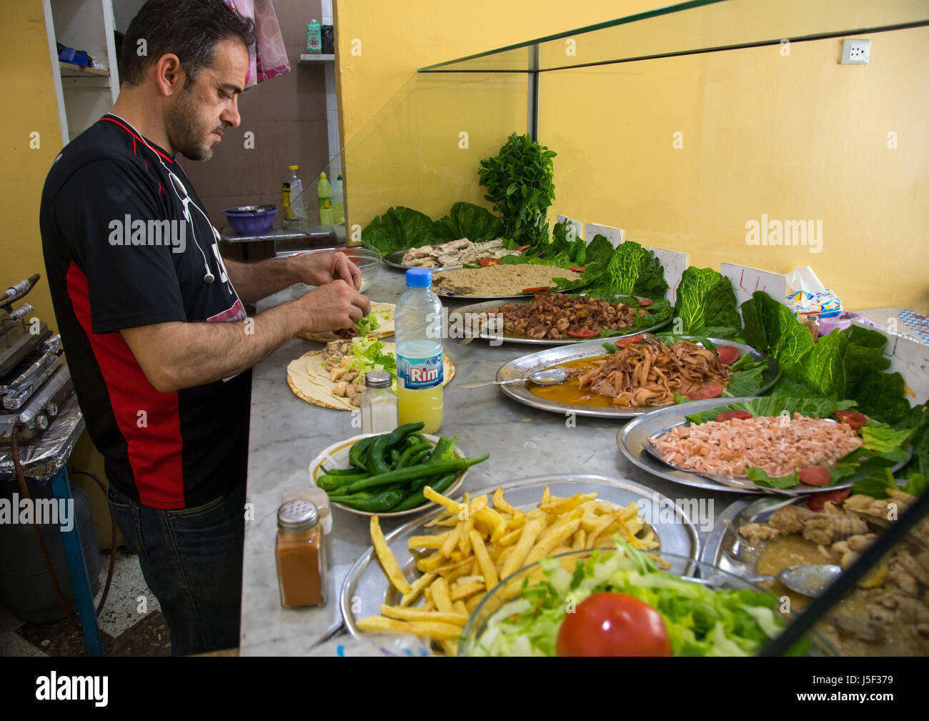 Lebanese man cooking fish in a local restaurant, North Governorate ...
