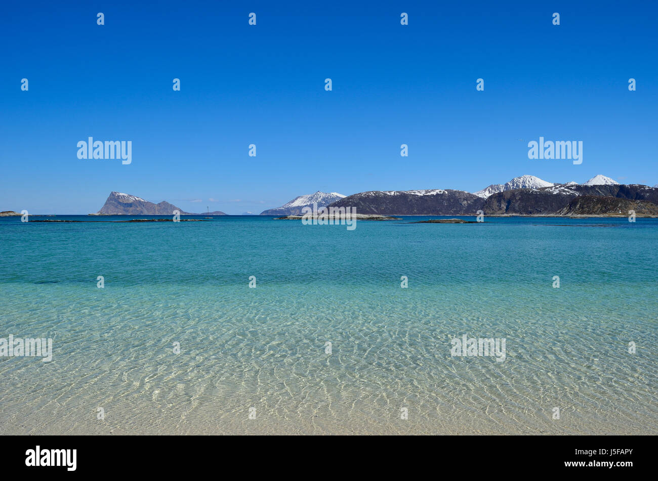 majestic white springtime beach with snowy mountain islands in sea on ...