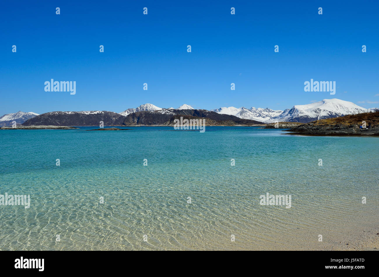 majestic white springtime beach with snowy mountain islands in sea on ...