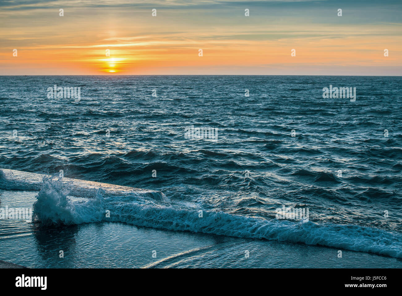 Waterfront ocean surf during sunset Stock Photo - Alamy