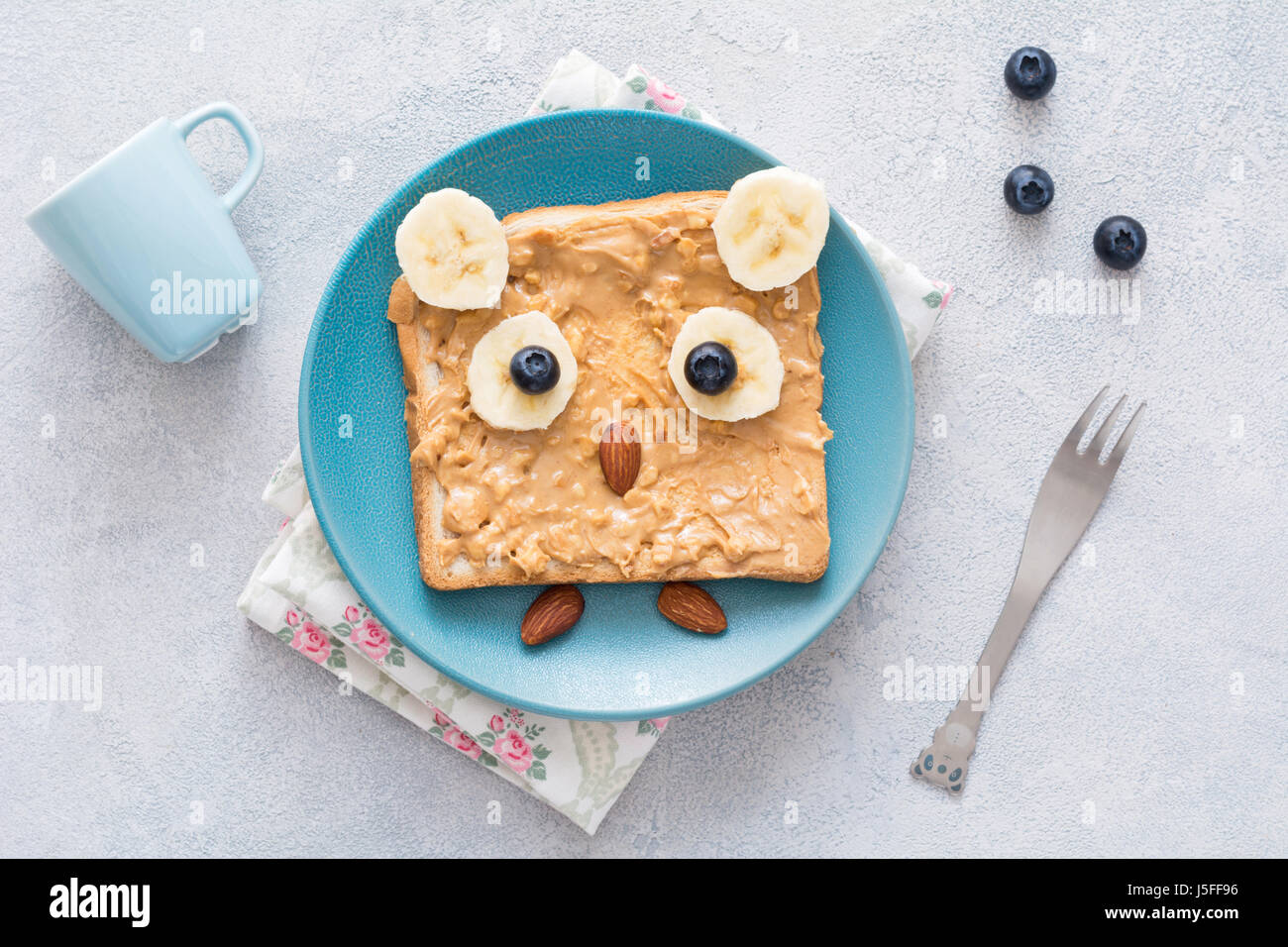 Peanut butter toast for kids in shape of funny cute owl on a blue plate ...