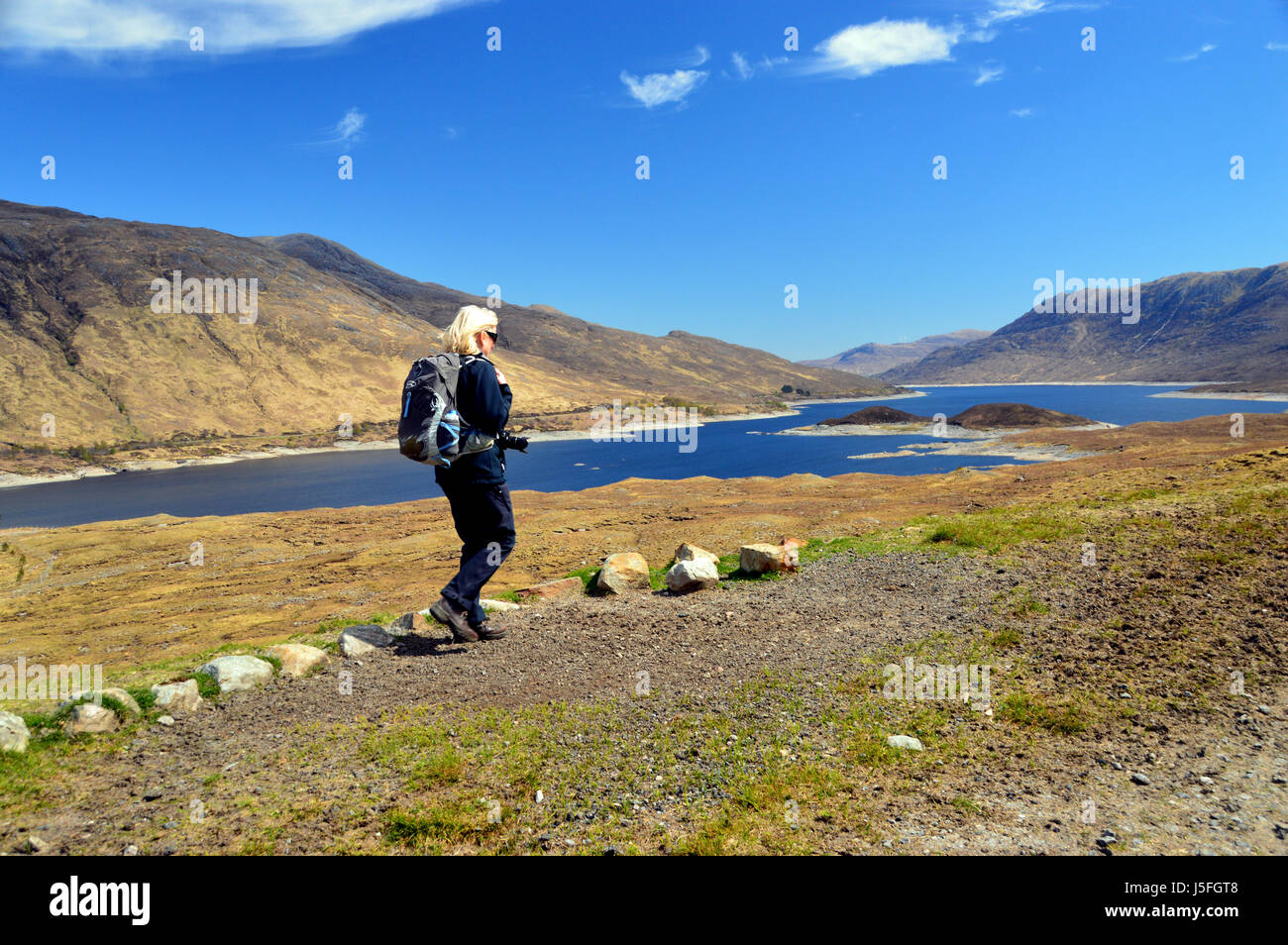 Lone Woman Hillwalker Walking on the old road to Tomdoun near Loch Cluanie in Glen Shiel ...