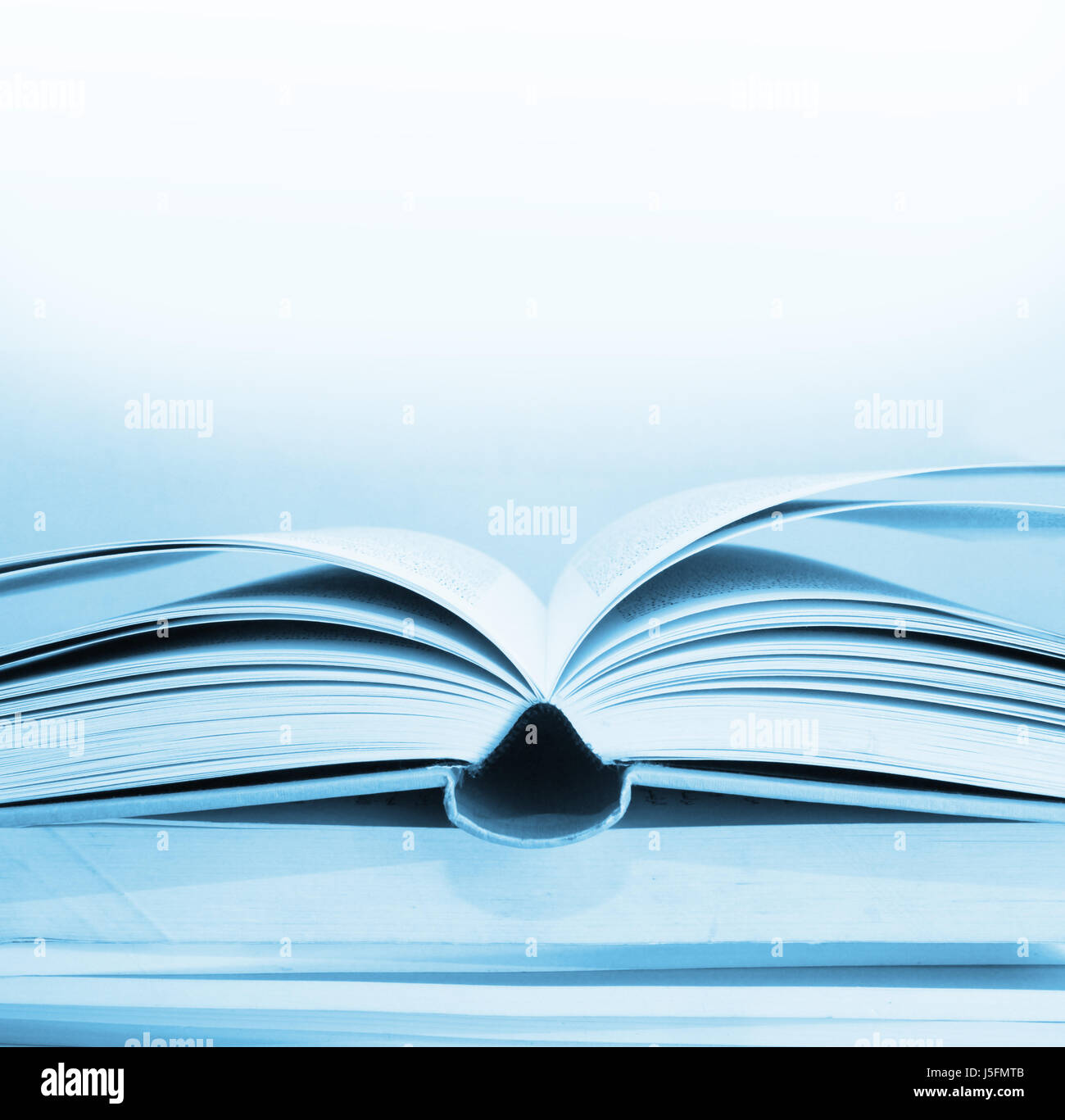 pile of books, one open, book arrangement Stock Photo - Alamy