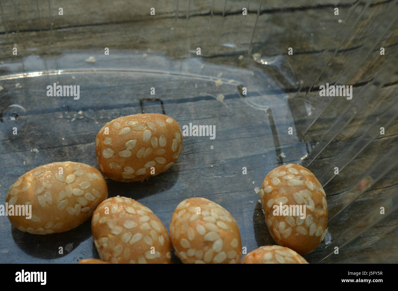 sesame seed covered candied peanuts Stock Photo - Alamy