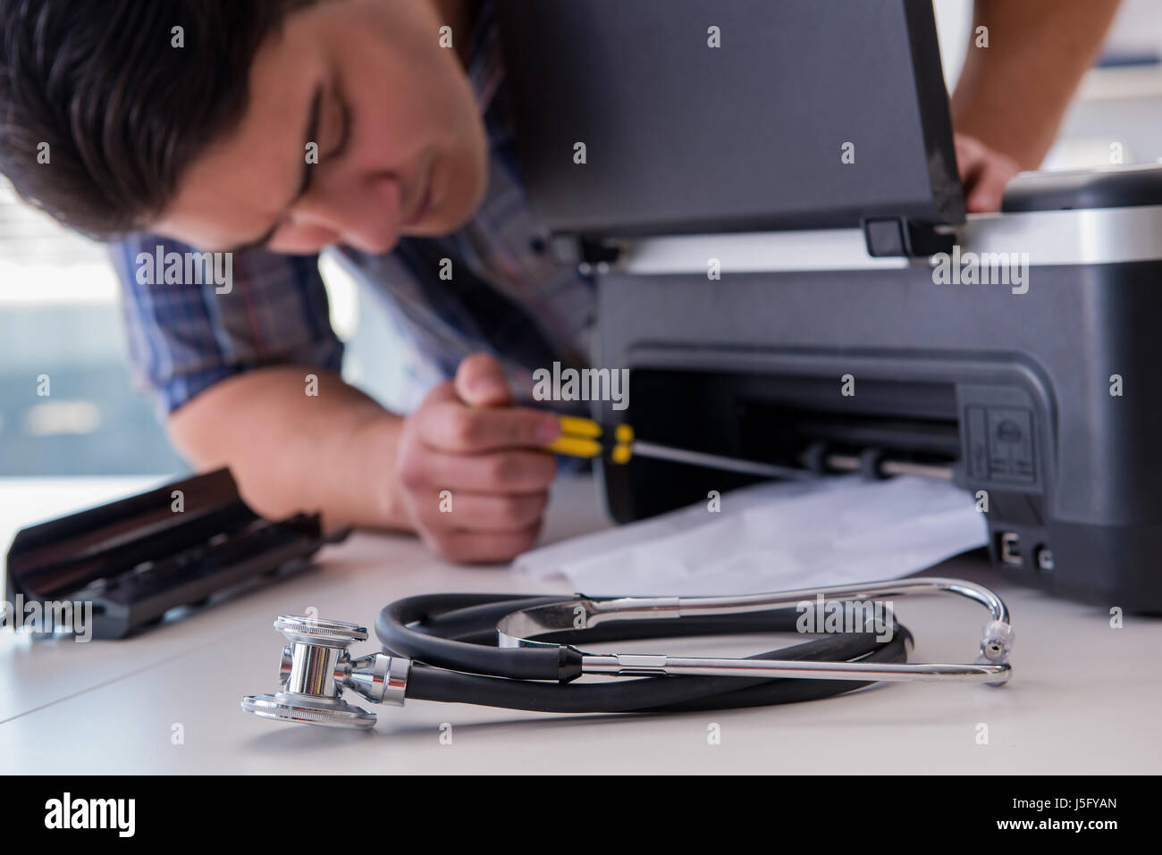 Repairman repairing broken color printer Stock Photo - Alamy