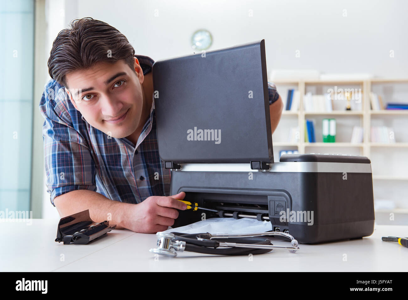 Repairman repairing broken color printer Stock Photo - Alamy