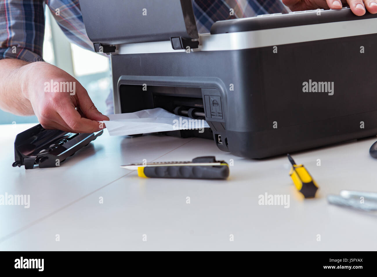 Repairman repairing broken color printer Stock Photo - Alamy