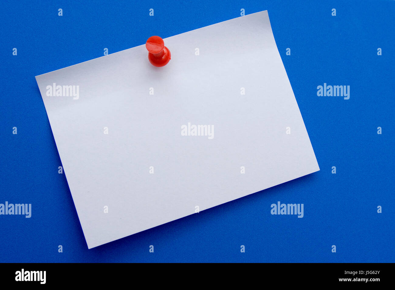 note with thumbtack on a blue background Stock Photo - Alamy