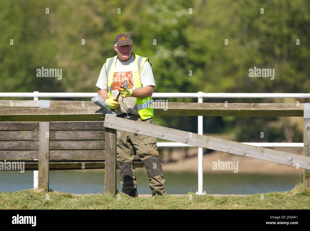 Man repairing wooden fence barrier Stock Photo - Alamy