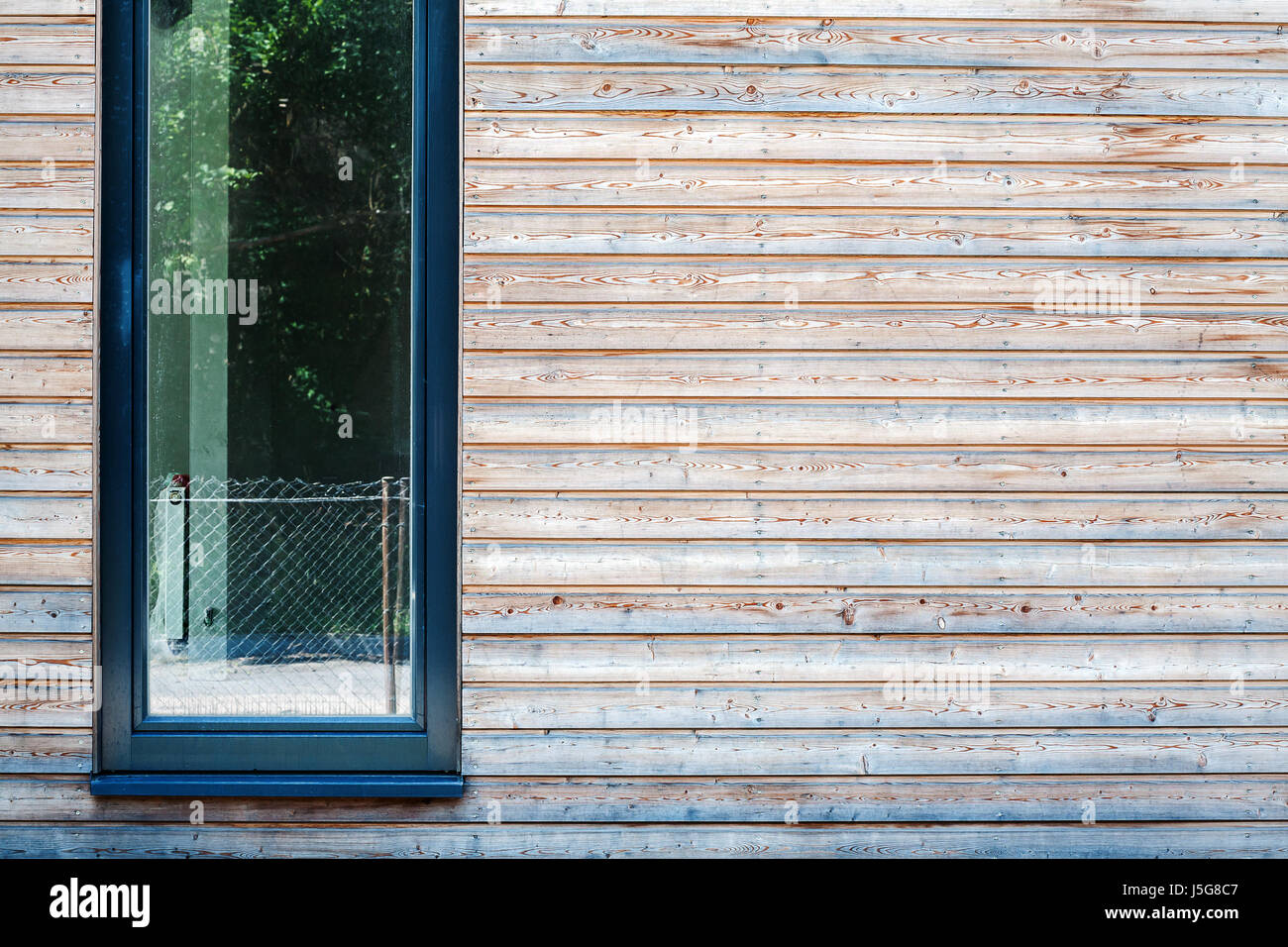 Modern window in a wooden plank wall Stock Photo - Alamy