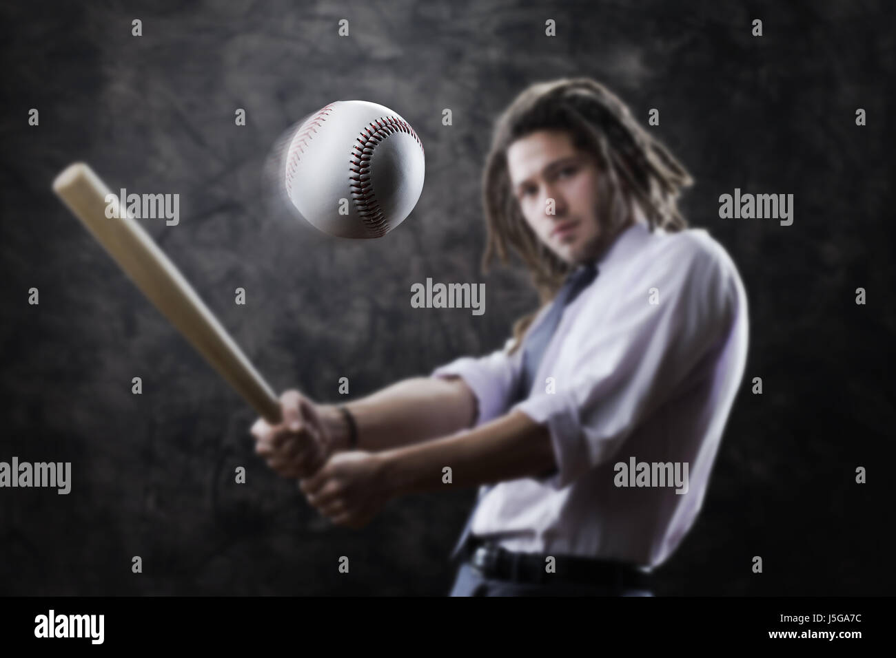 Young businessman swinging baseball bat Stock Photo - Alamy