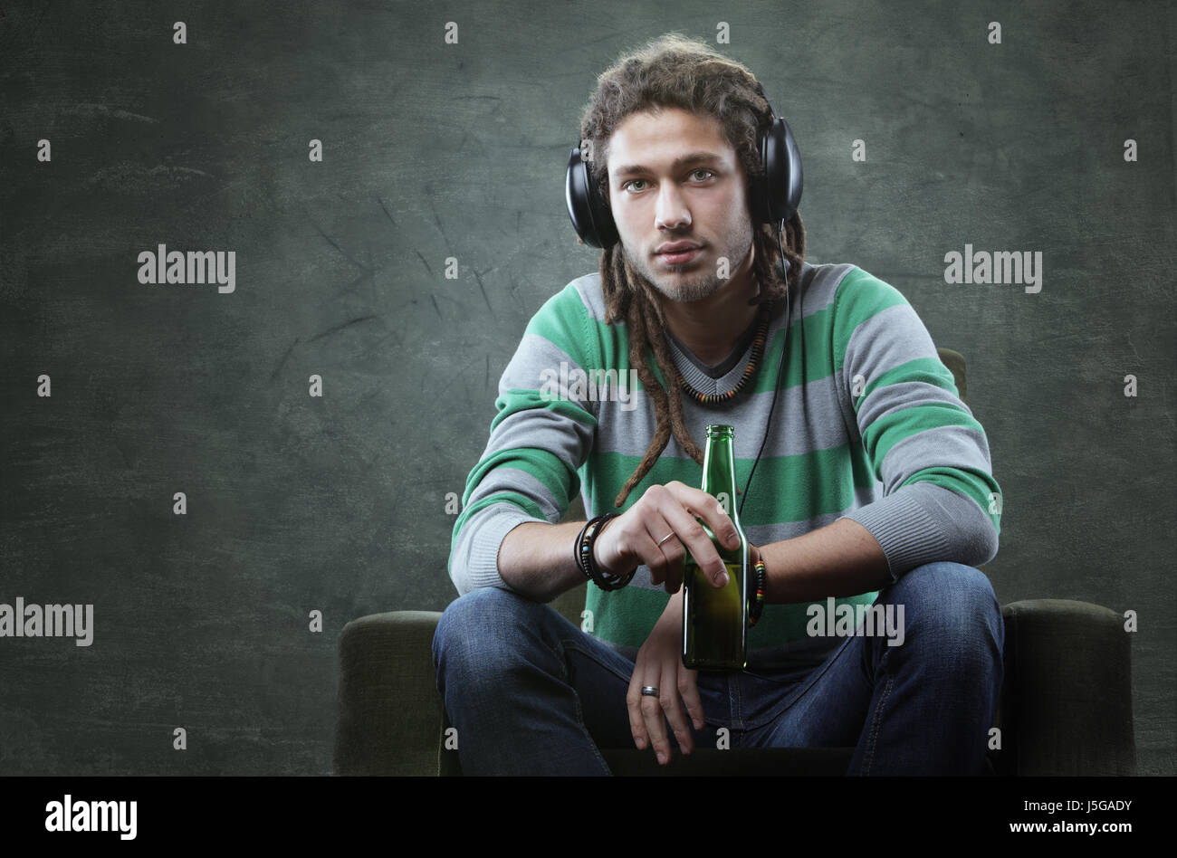 Relaxed young guy listening to music with headphones Stock Photo - Alamy