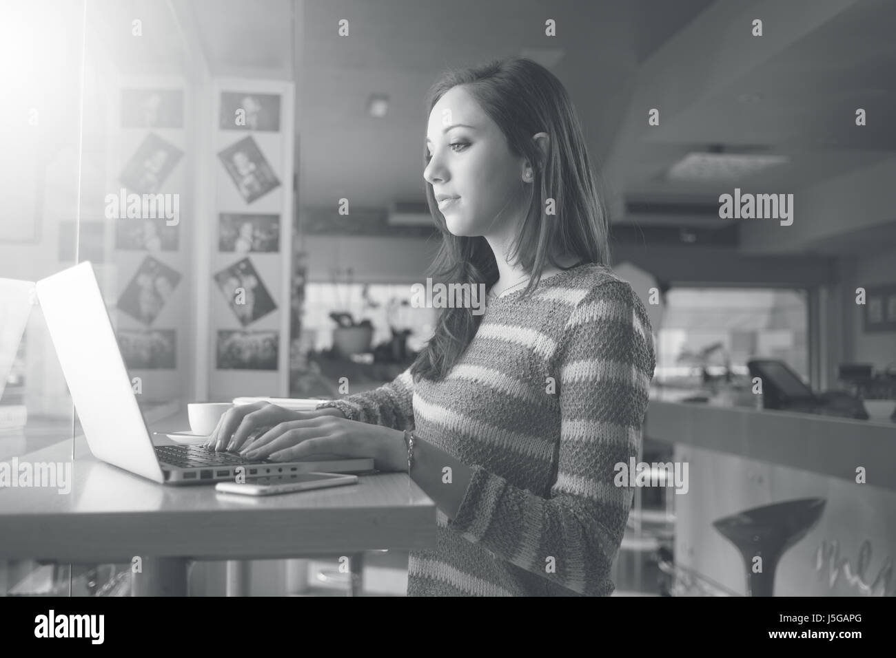 Busy young woman using a laptop and staring at computer screen Stock ...