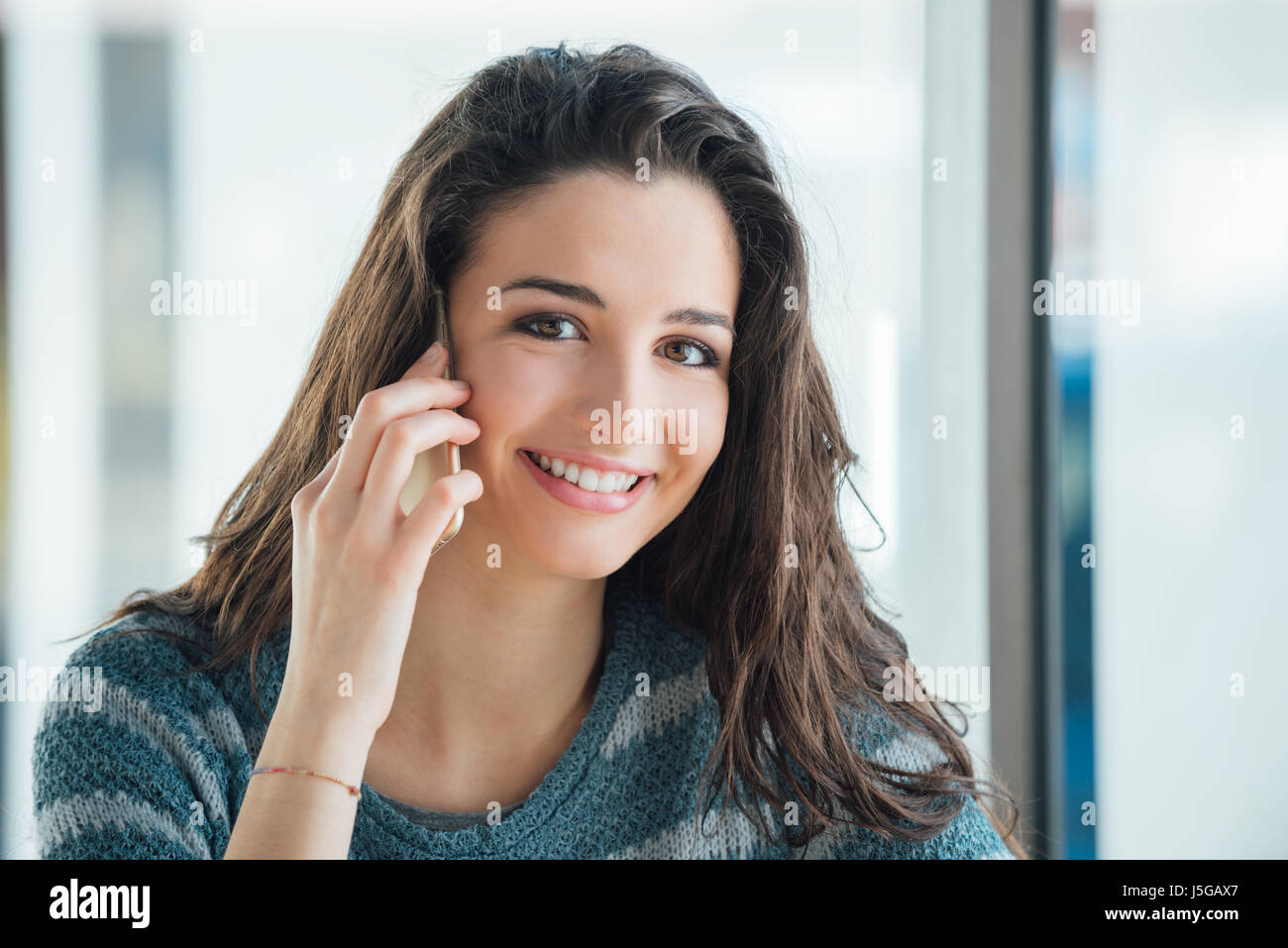 Cheerful young woman on the phone having a call Stock Photo - Alamy