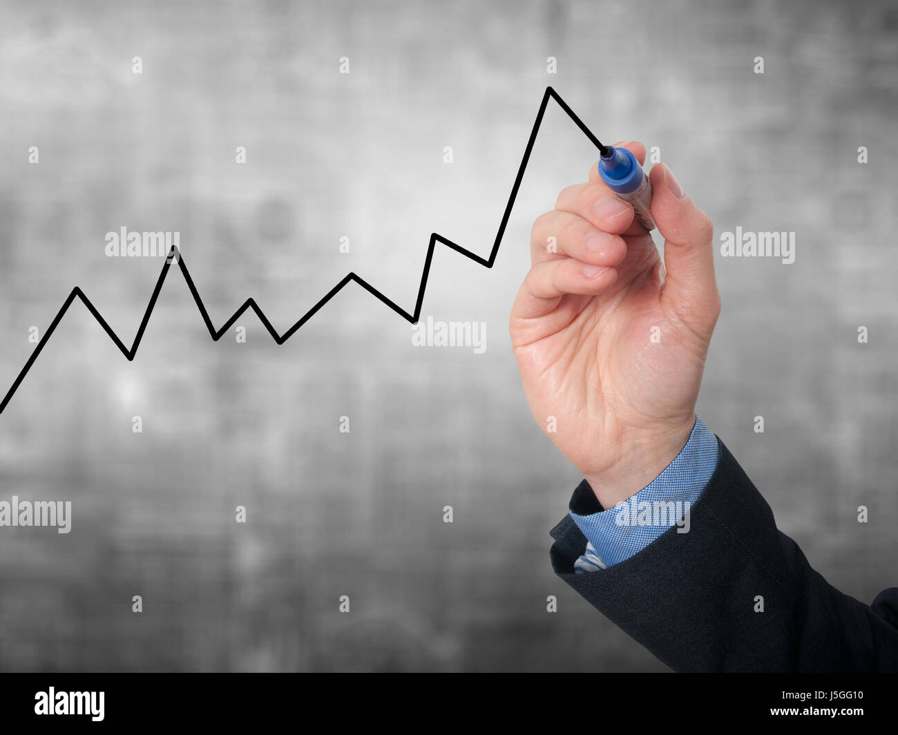 Businessman hand drawing graph of growth. Isolated on grey background ...