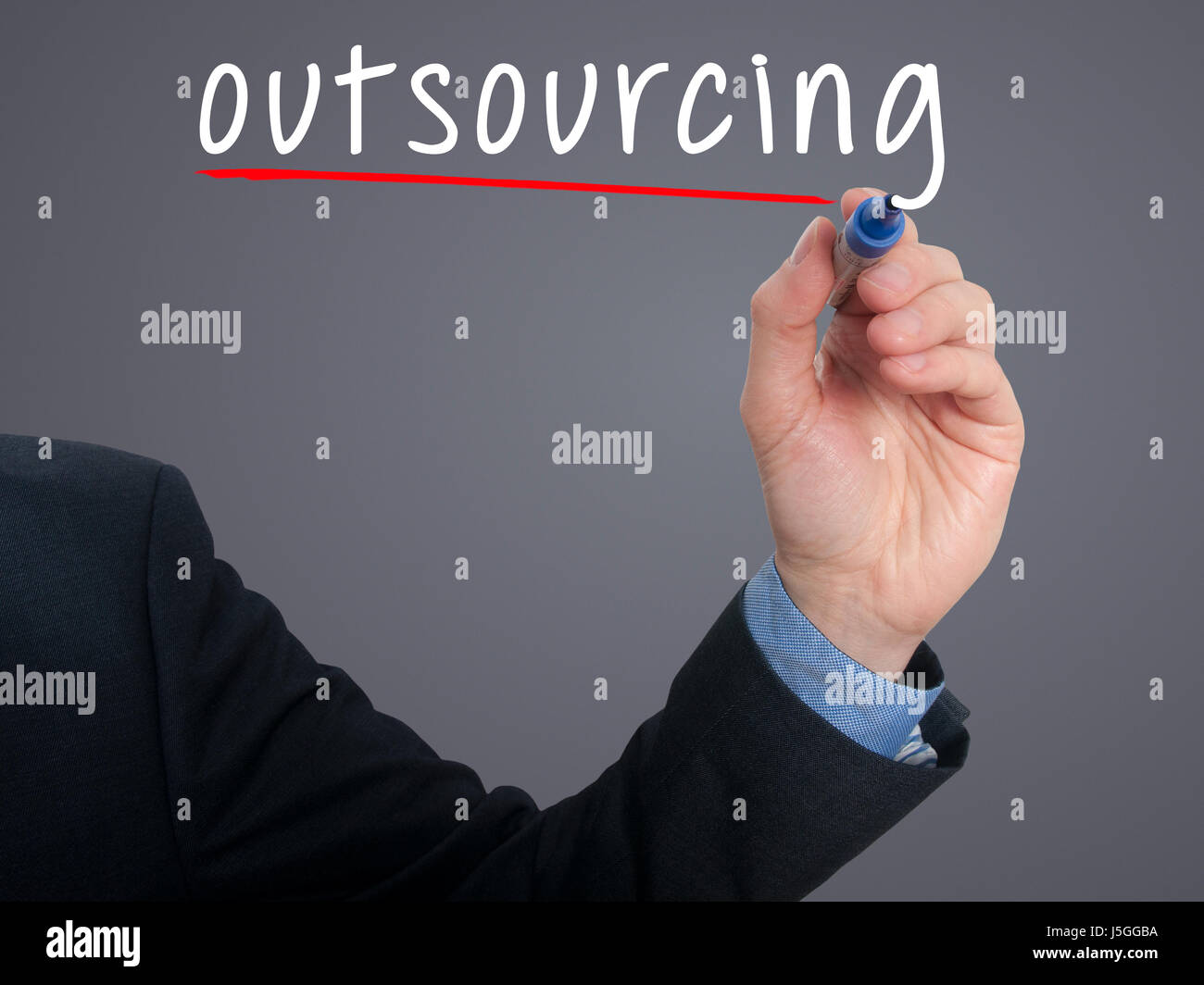 Businessman hand writing Outsourcing isolated on grey background ...