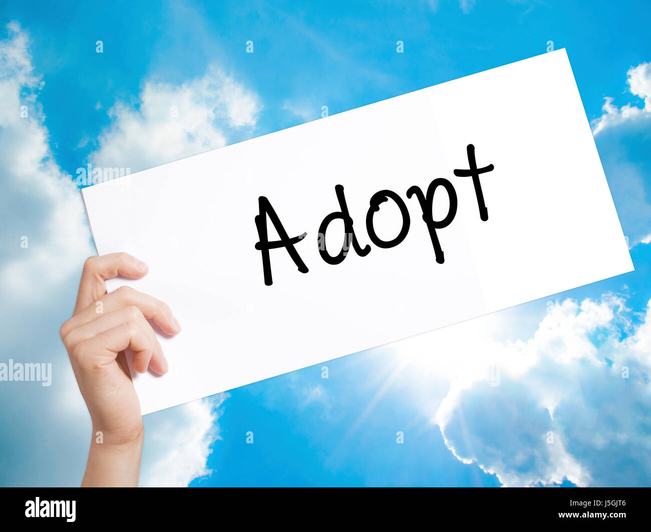 Adopt Sign on white paper. Man Hand Holding Paper with text. Isolated ...