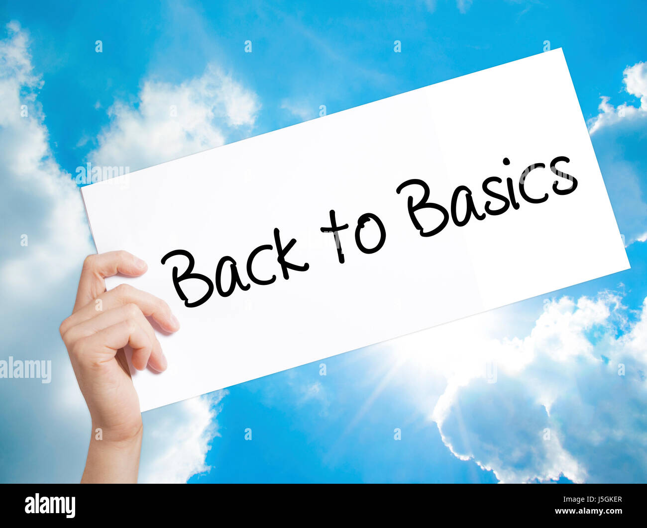 Back to Basics Sign on white paper. Man Hand Holding Paper with text ...