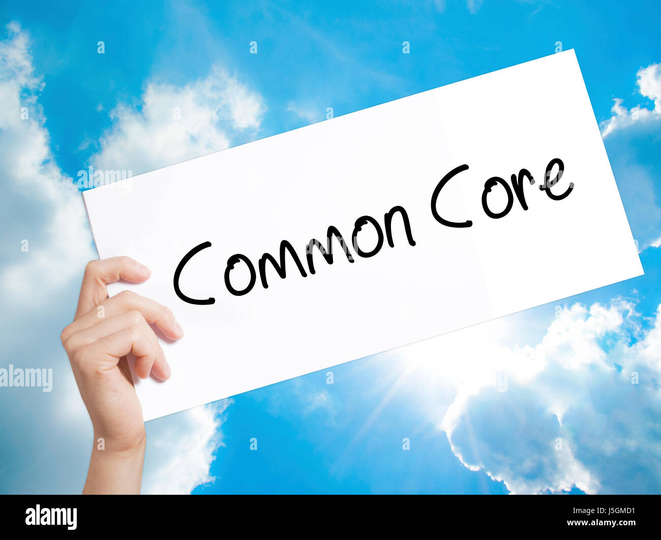Common Core Sign on white paper. Man Hand Holding Paper with text ...
