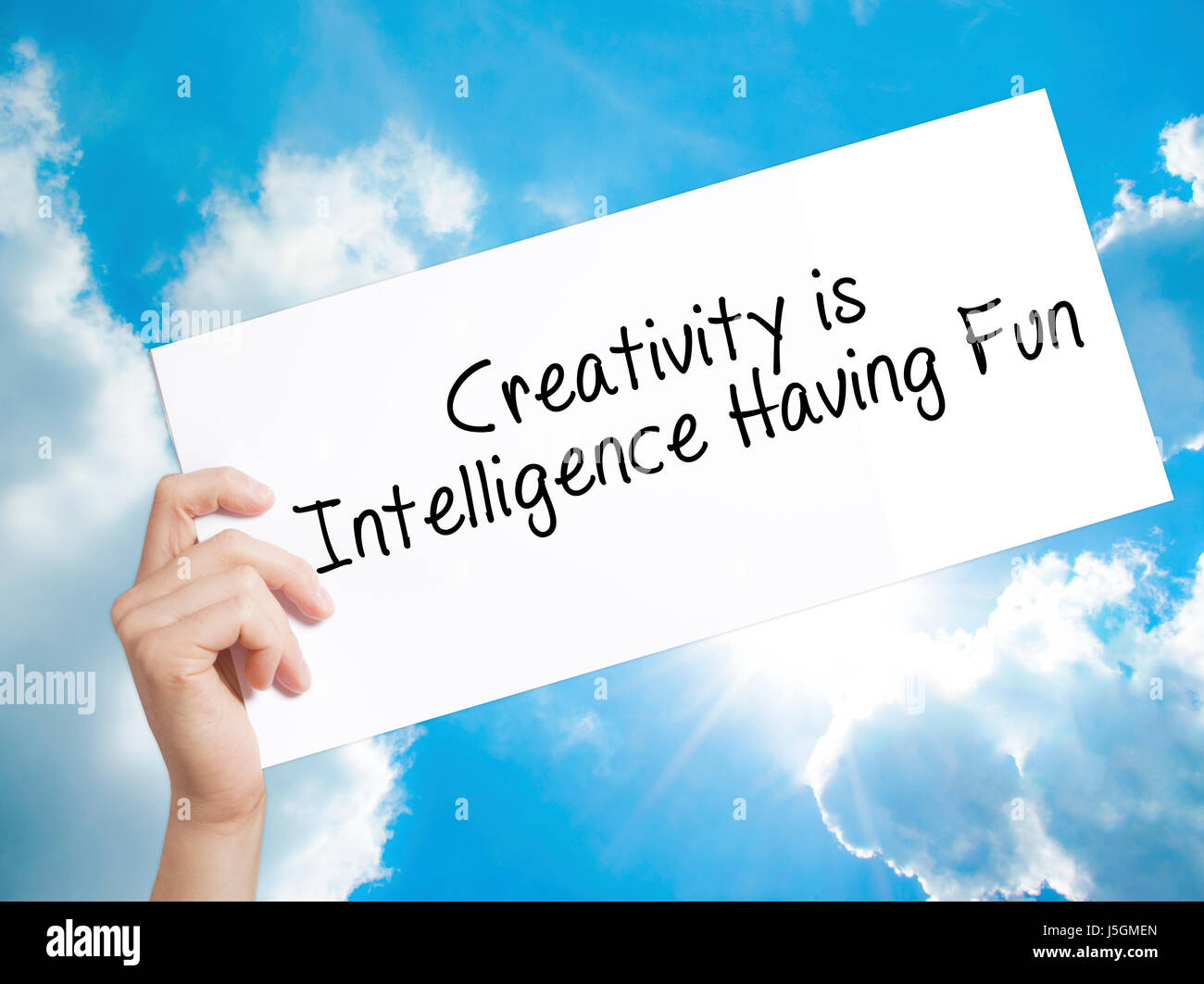 Creativity is Intelligence Having Fun Sign on white paper. Man Hand ...