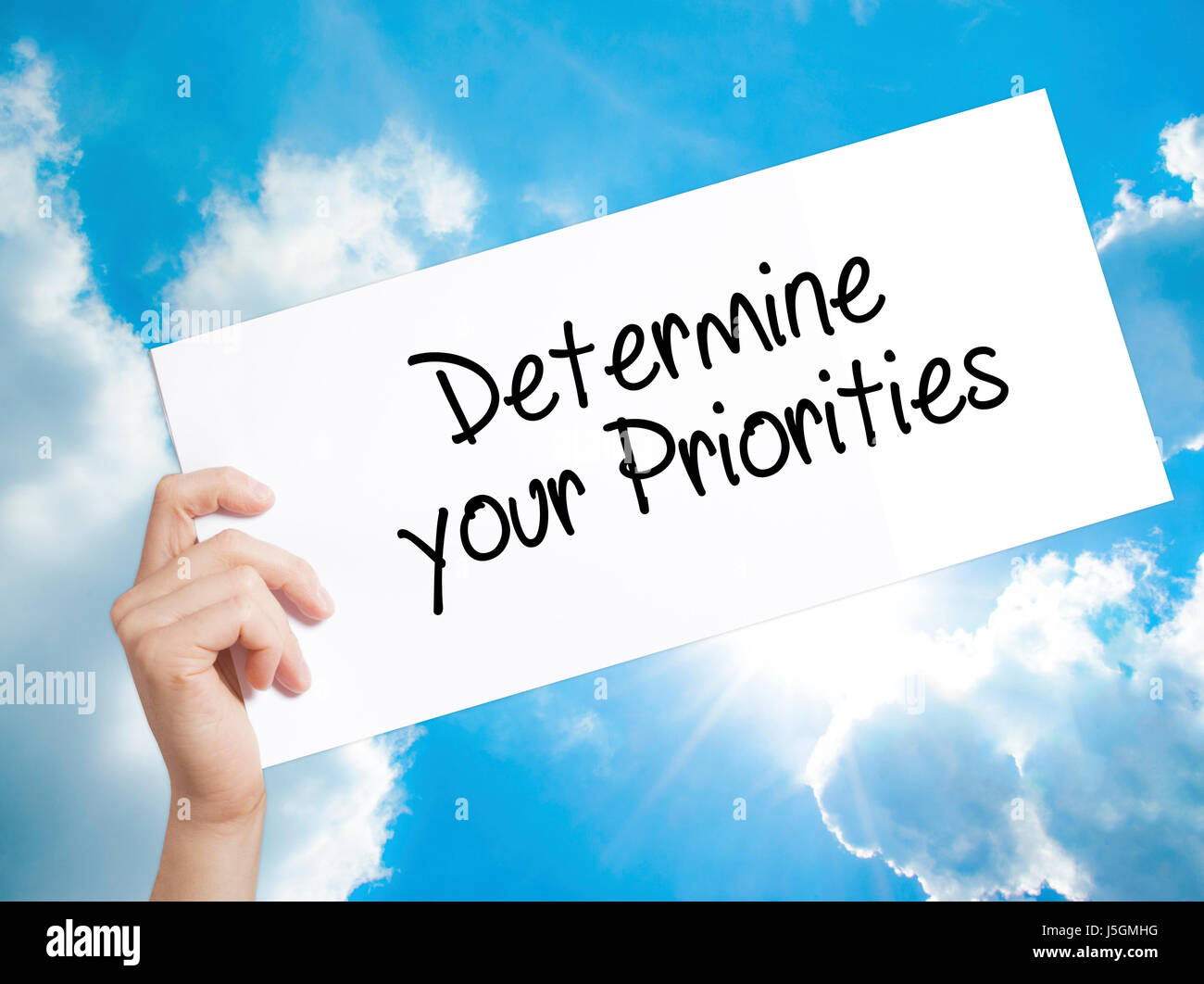 Determine your Priorities Sign on white paper. Man Hand Holding Paper ...