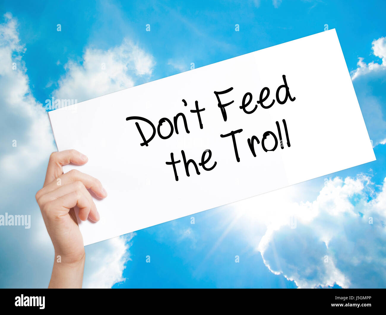 Don't Feed the Troll Sign on white paper. Man Hand Holding Paper with ...