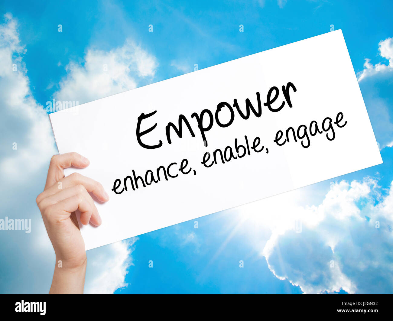 Empower enhance, enable, engage Sign on white paper. Man Hand Holding ...