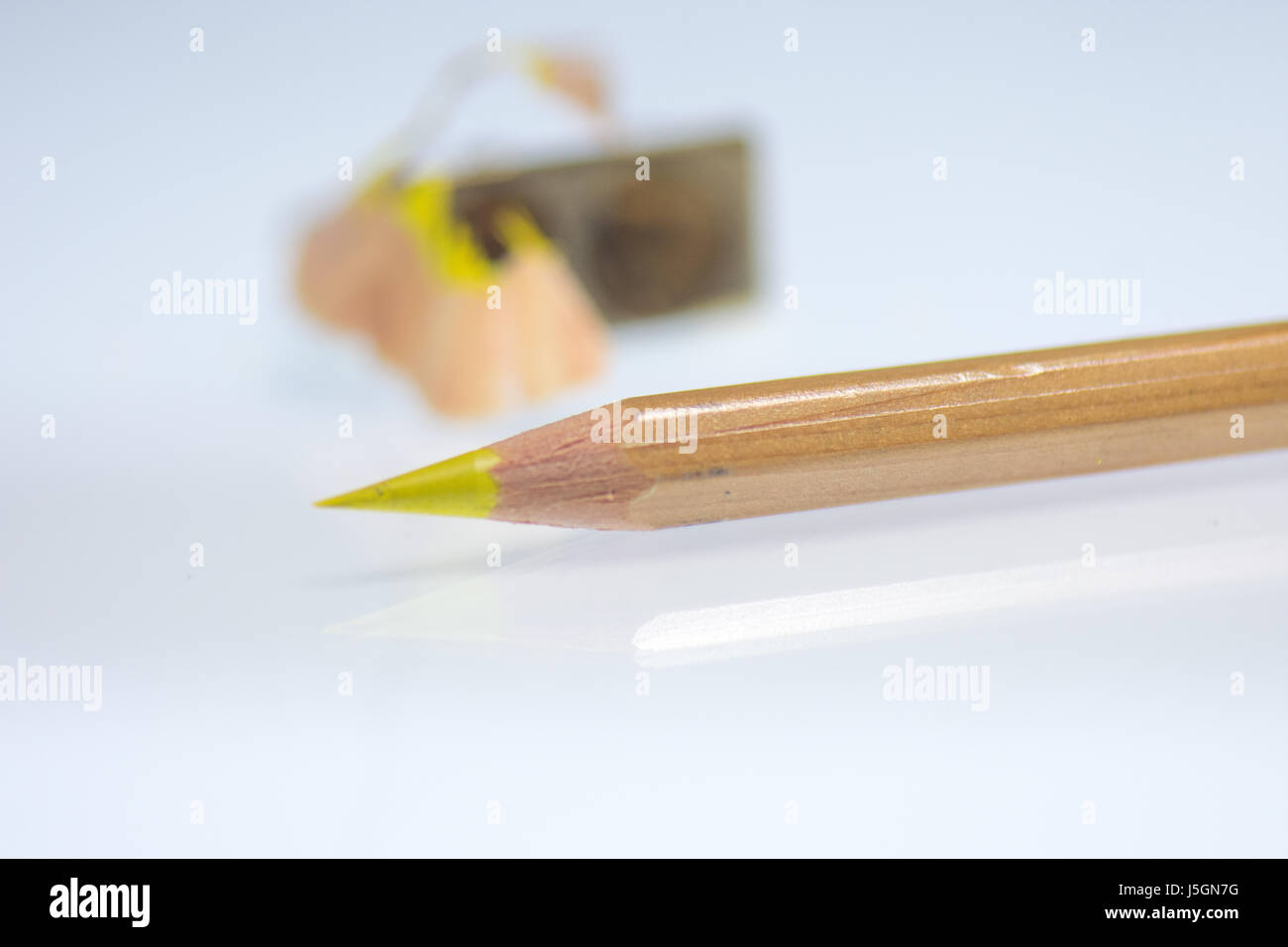 A sharpened yellow pencil in front of a pencil sharpener Stock Photo ...