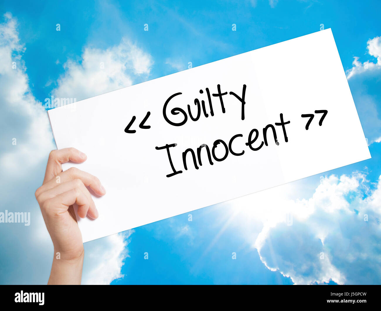 Guilty - Innocent Sign on white paper. Man Hand Holding Paper with text ...