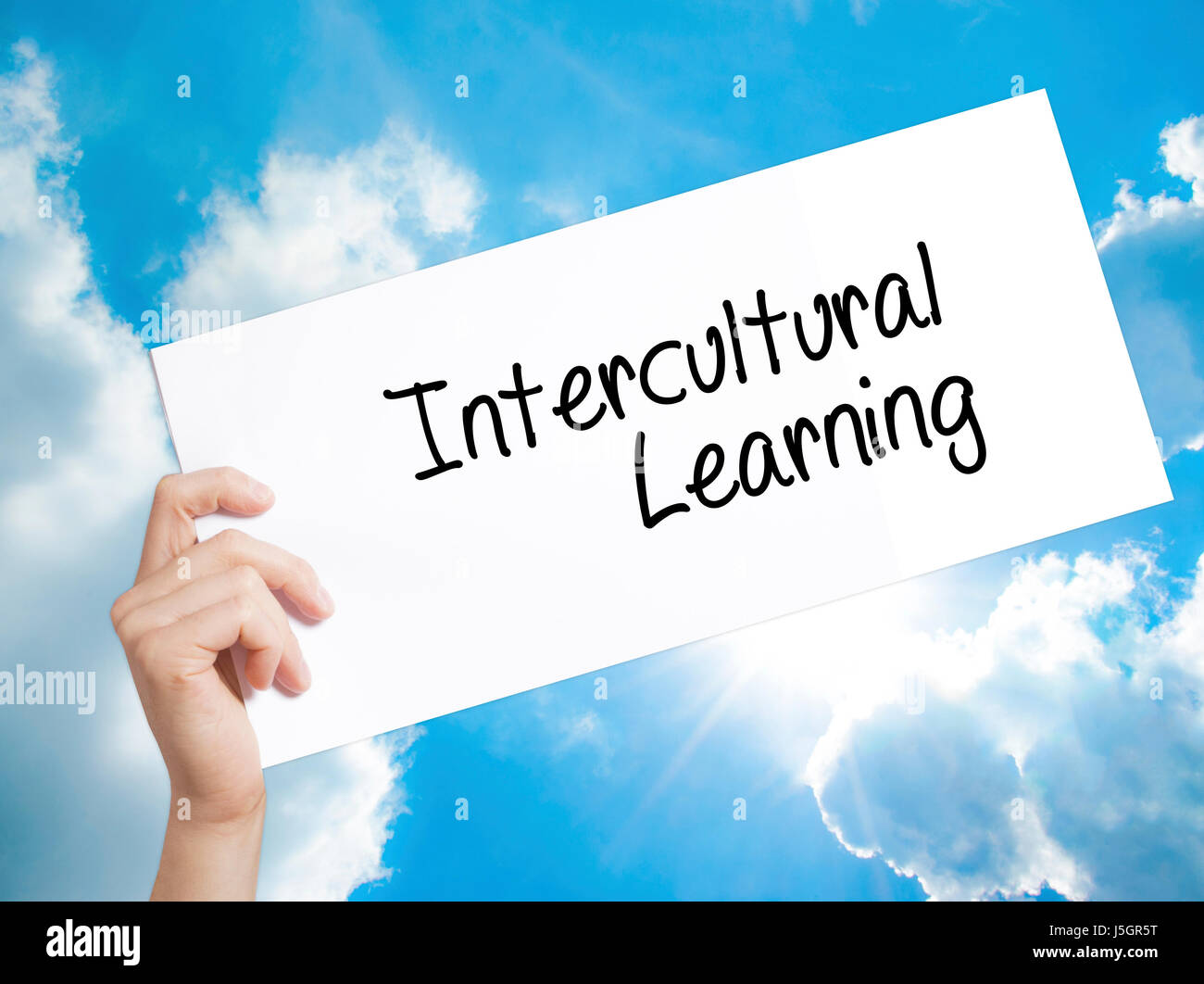Intercultural Learning Sign on white paper. Man Hand Holding Paper with ...