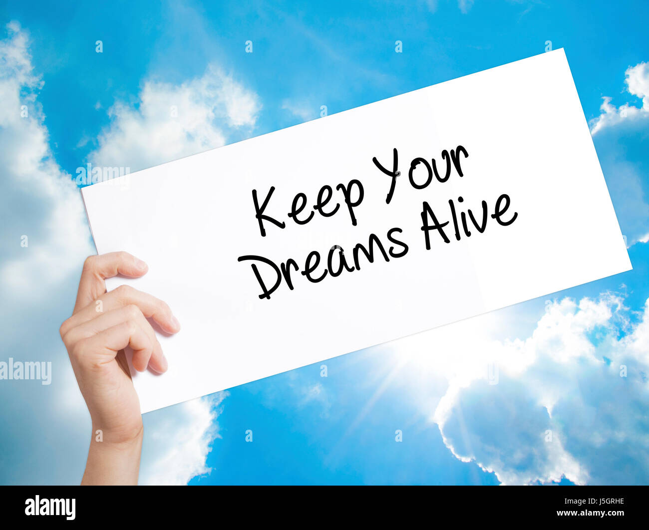 Keep Your Dreams Alive Sign on white paper. Man Hand Holding Paper with ...