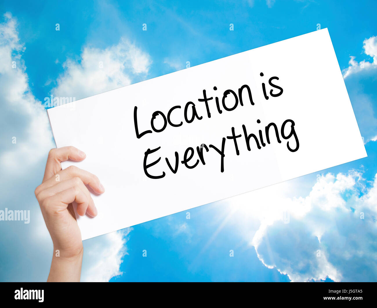 Location is Everything Sign on white paper. Man Hand Holding Paper with ...
