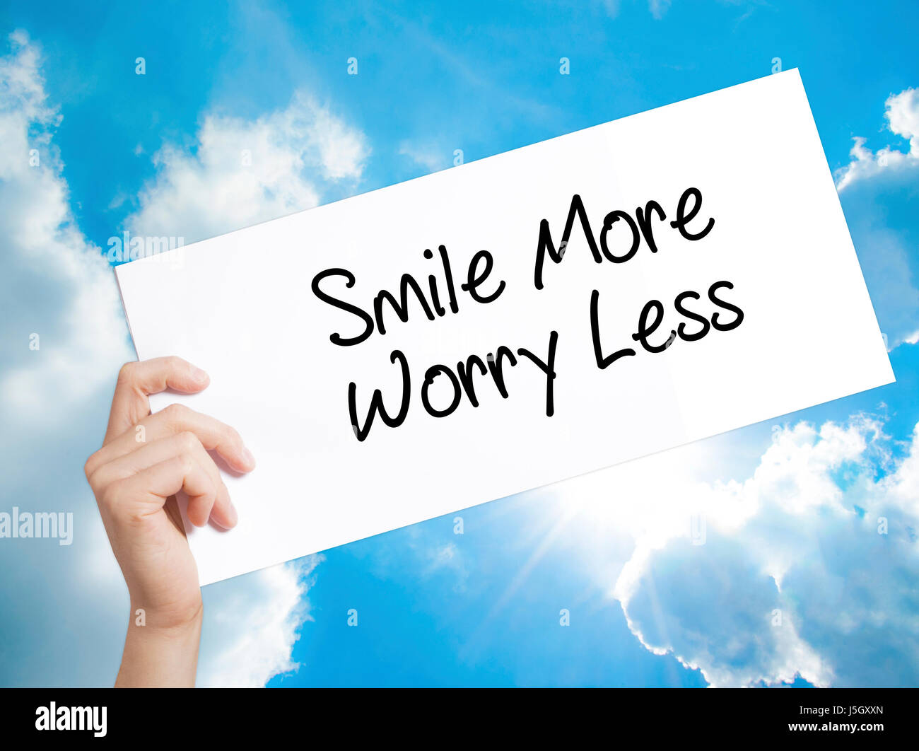 Smile More Worry Less Sign on white paper. Man Hand Holding Paper with ...