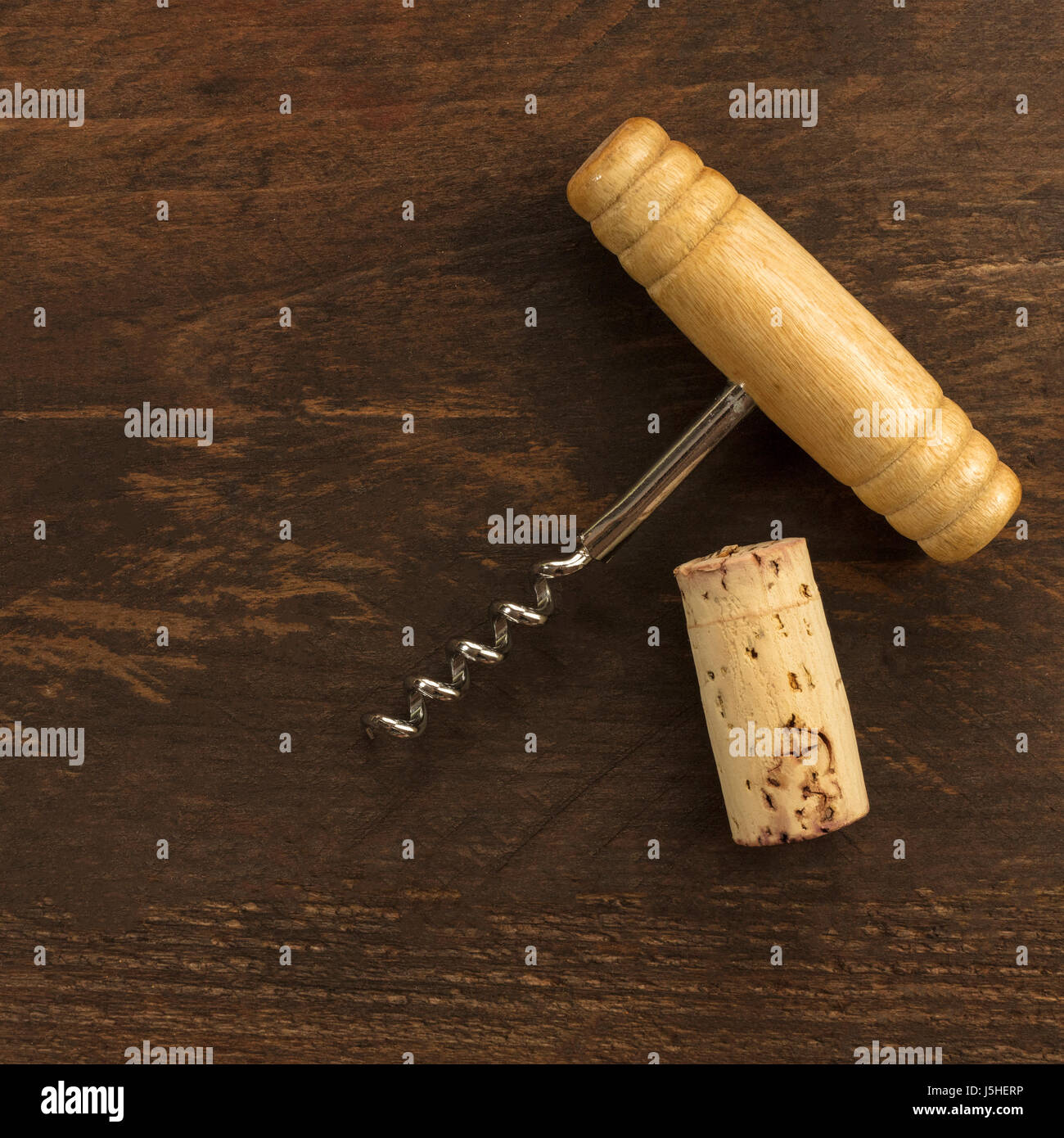 A photo of an old-fashioned corkscrew with a cork, shot from above on a ...