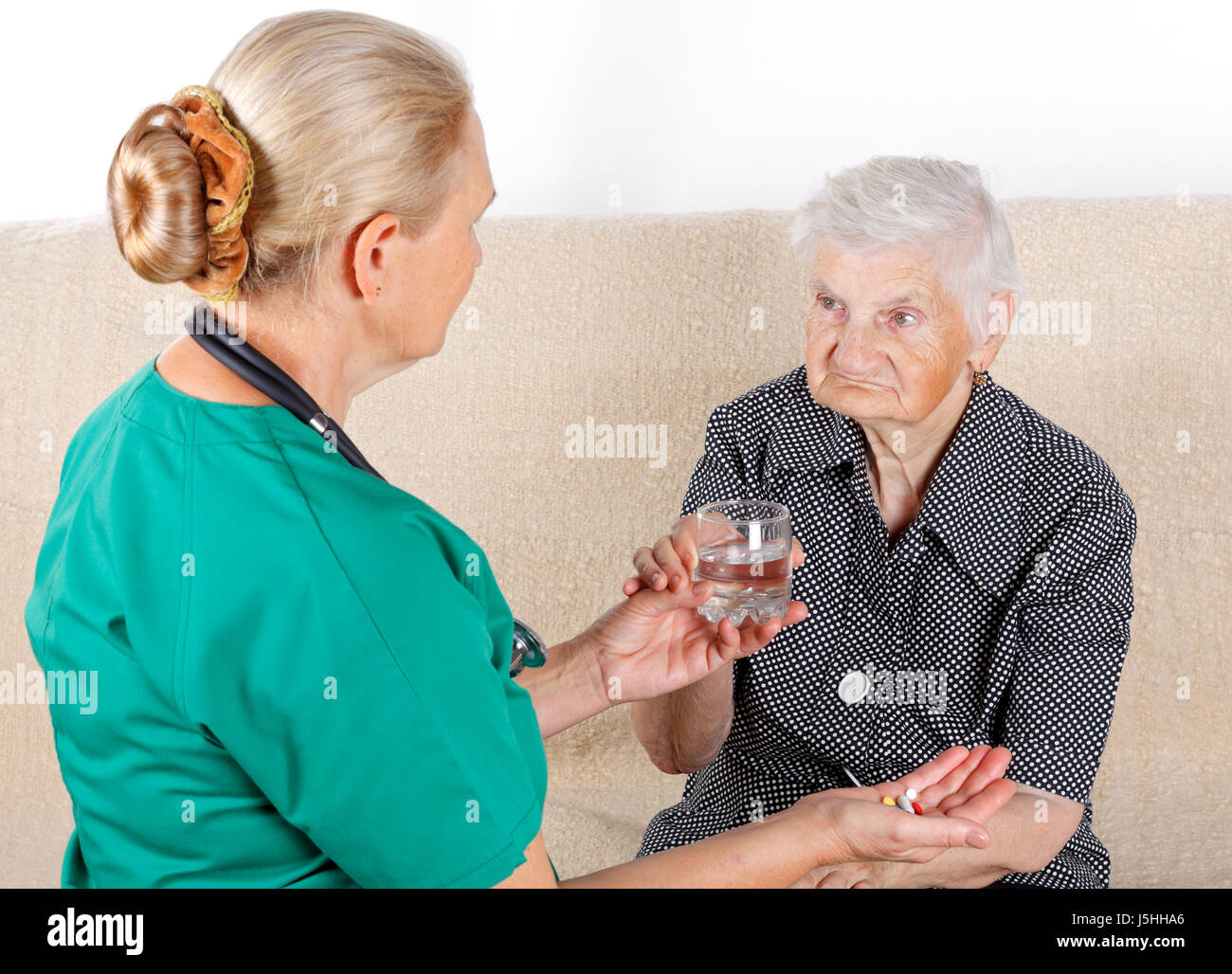 Female doctor helping a sick senior lady Stock Photo - Alamy