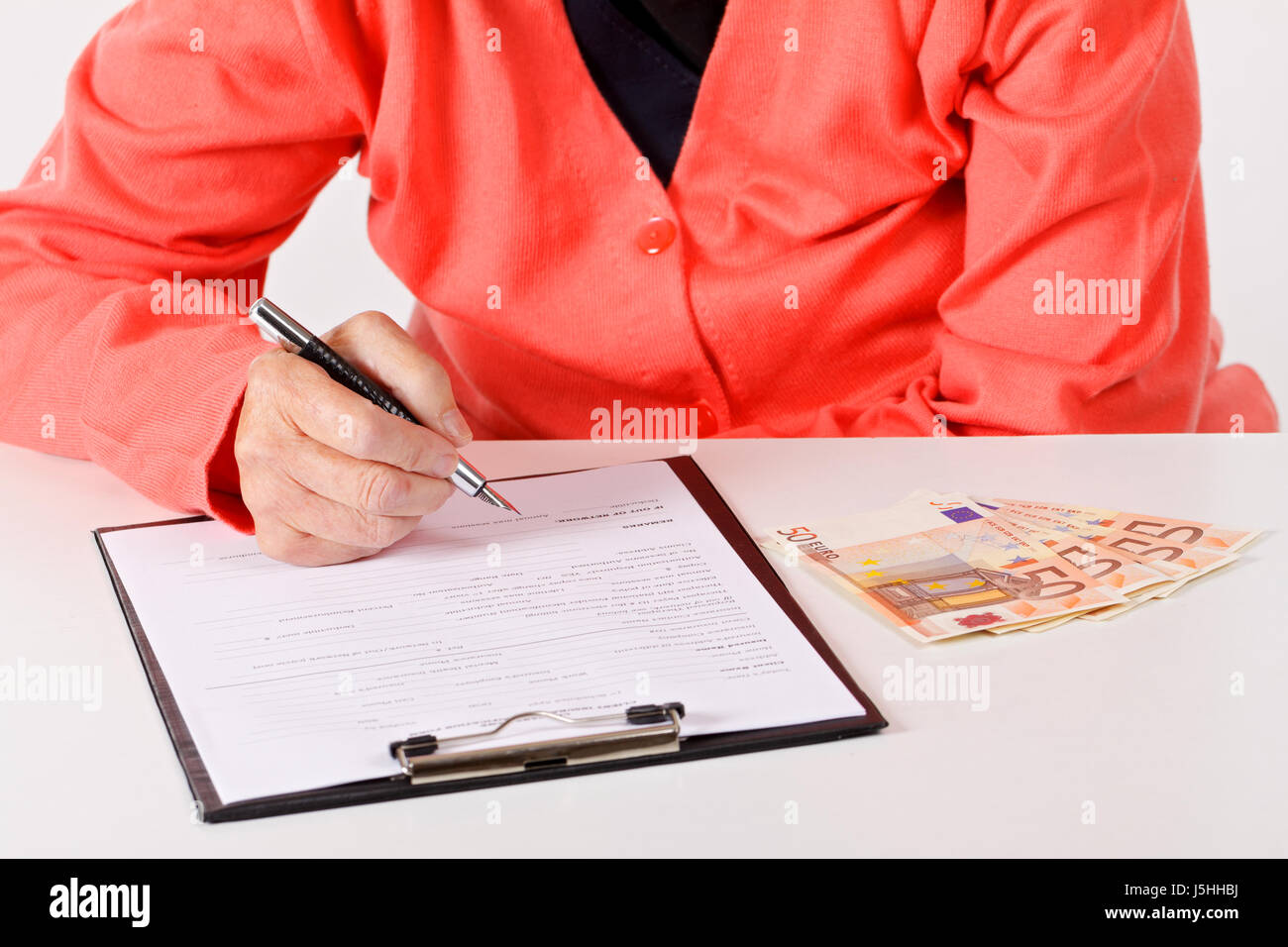 A senior woman's hand signing on a document Stock Photo - Alamy
