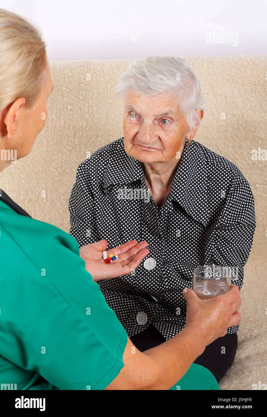 Female doctor helping a sick senior lady Stock Photo - Alamy