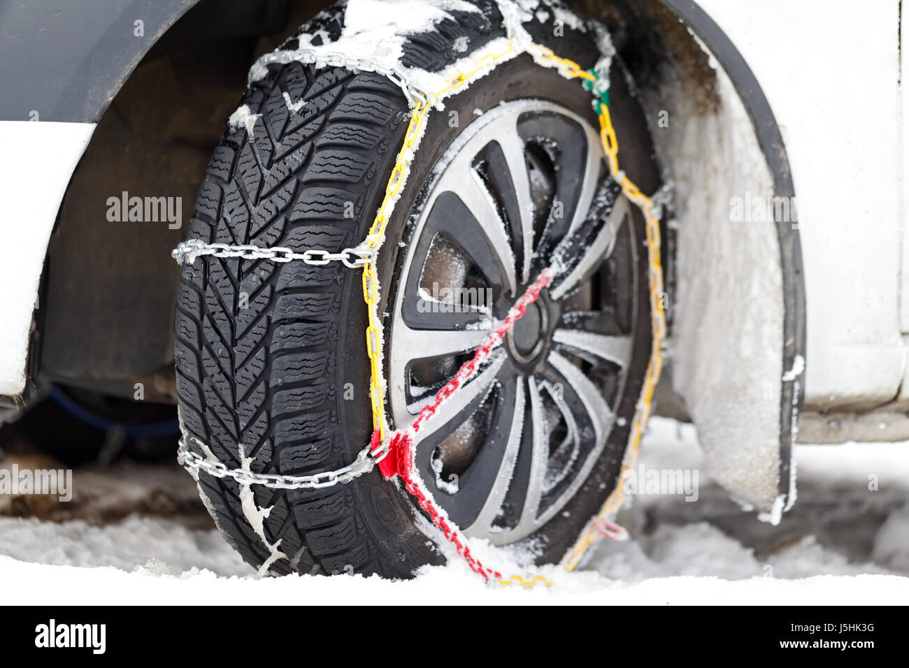 Photo of a vehicle tyre with snow chains on a frozen road Stock Photo ...