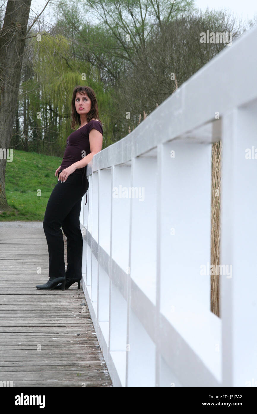 brunette woman leaning on railing Stock Photo - Alamy