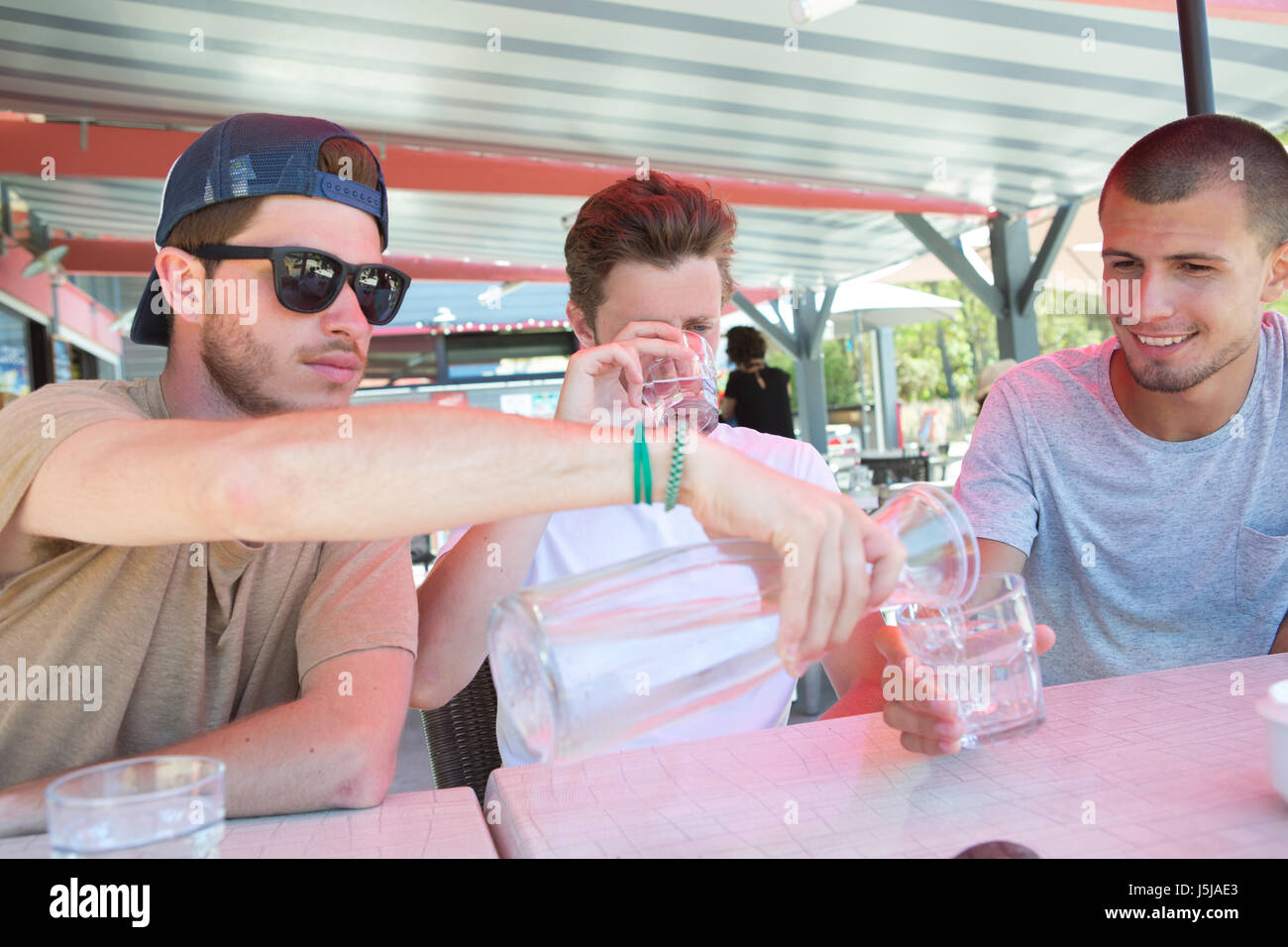 pouring water to a friends glass Stock Photo - Alamy