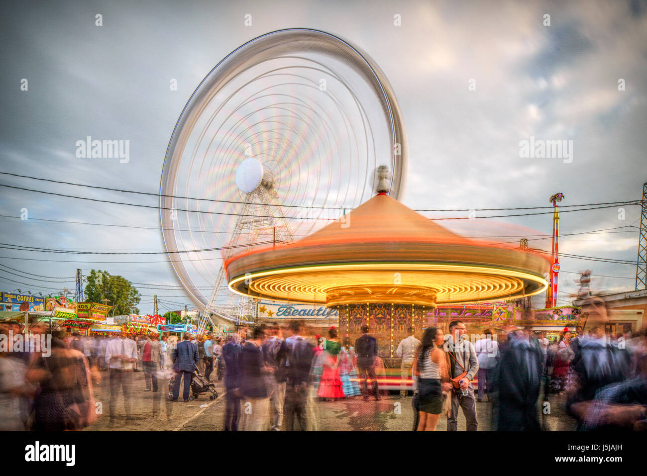 Carousel and Ferris wheel in a funfair, Feria de Abril, Seville, Spain ...