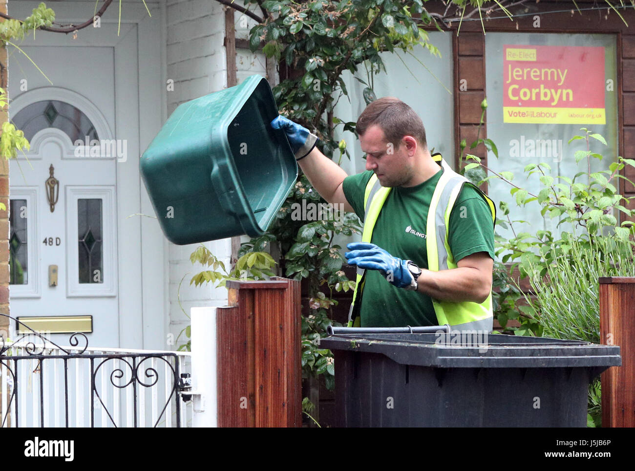 An Islington waste removal worker empties the bins in front of Labour ...