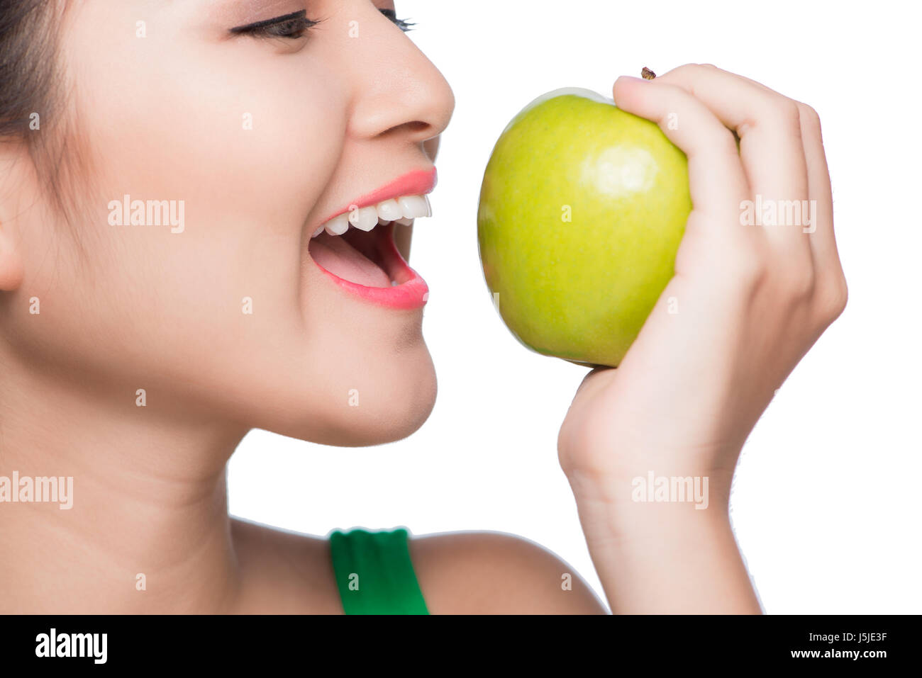 Young beautiful asian woman eating fresh green apple on white ...
