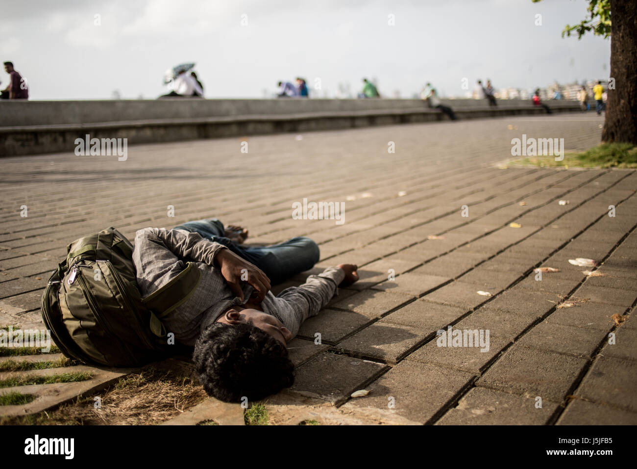 A student taking a little nap on the road at lunch time in Mumbai ...