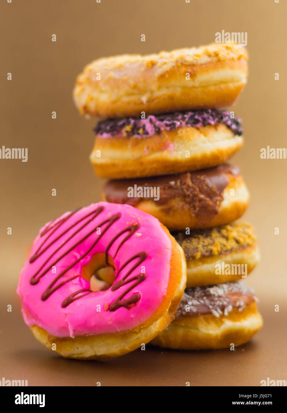 Stack of assorted donuts in a soft brown background Stock Photo - Alamy