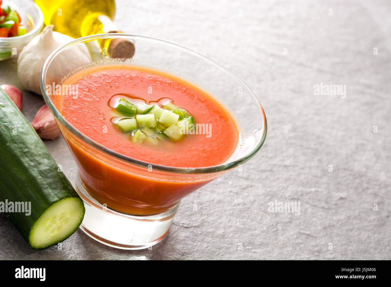 Traditional Spanish cold gazpacho soup and ingredients on gray stone ...