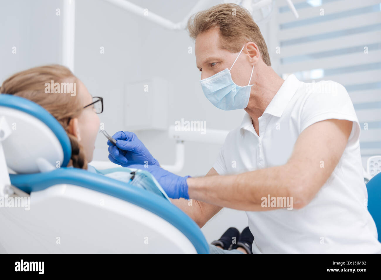 Dedicated local dentist focused on his task Stock Photo - Alamy