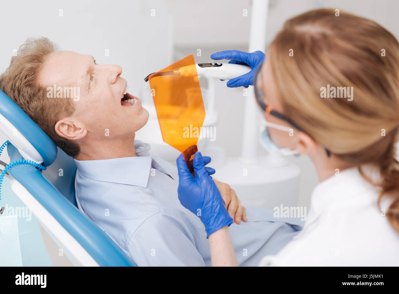 Focused smart man undergoing dental manipulation Stock Photo - Alamy