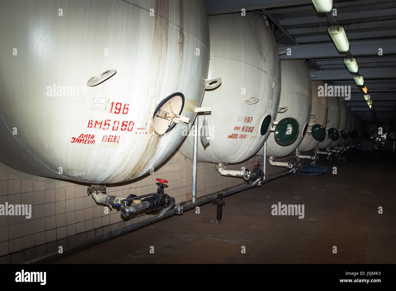 Industrial Champagne wine storage, large cisterns in a huge dark vault ...